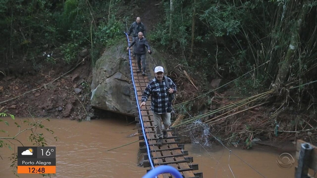 Comunidade constrói ponte provisória para acessar área alagada em ...
