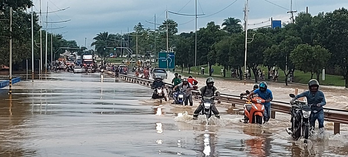 Motoristas e pedestres se arriscam para atravessar em rodovia alagada ...