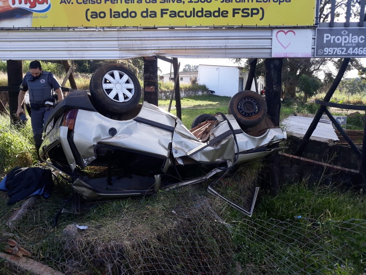 Motorista fica ferido após perder o controle de carro, invadir terreno, bater em placa e capotar ...